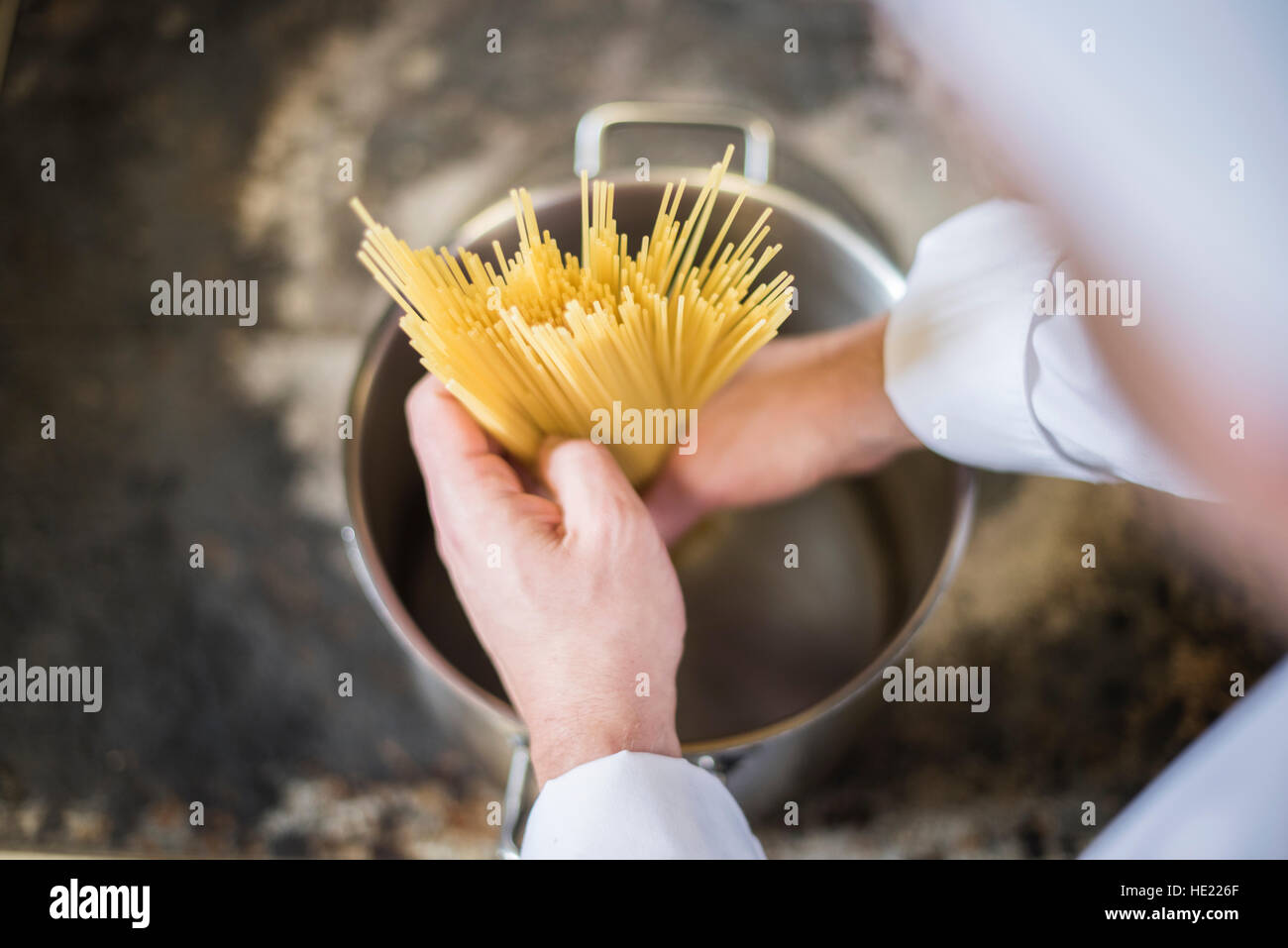Chef inserting pasta to the kitchen pot Stock Photo - Alamy
