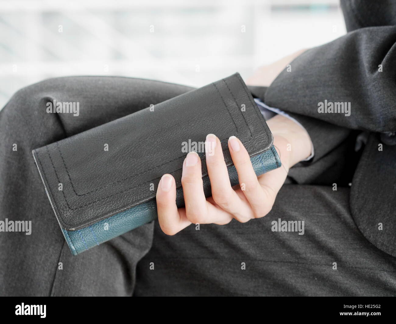 Female hand holding black leather wallet Stock Photo - Alamy