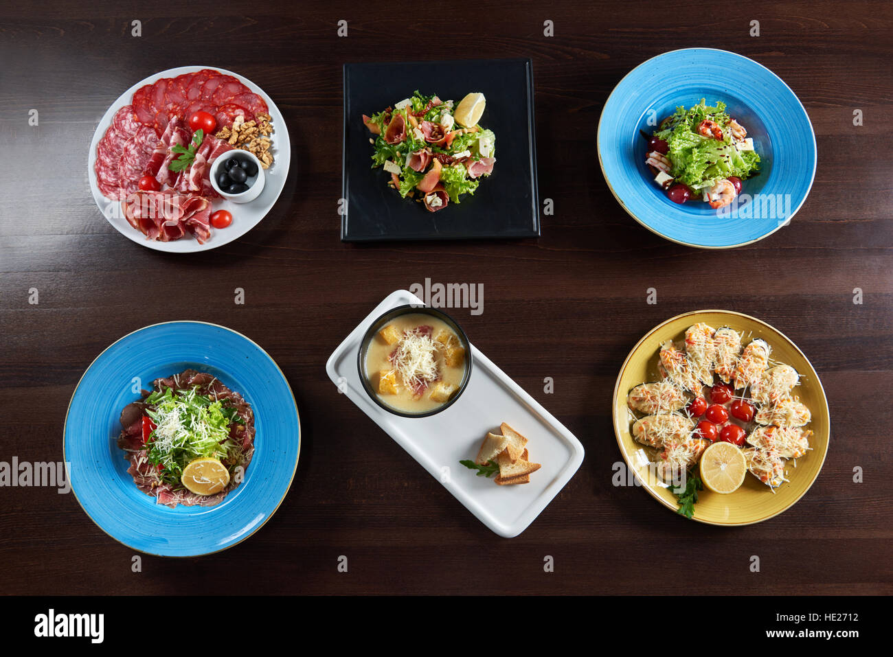 Food heaven. Top view of a restaurant table with plates of salads bowl ...