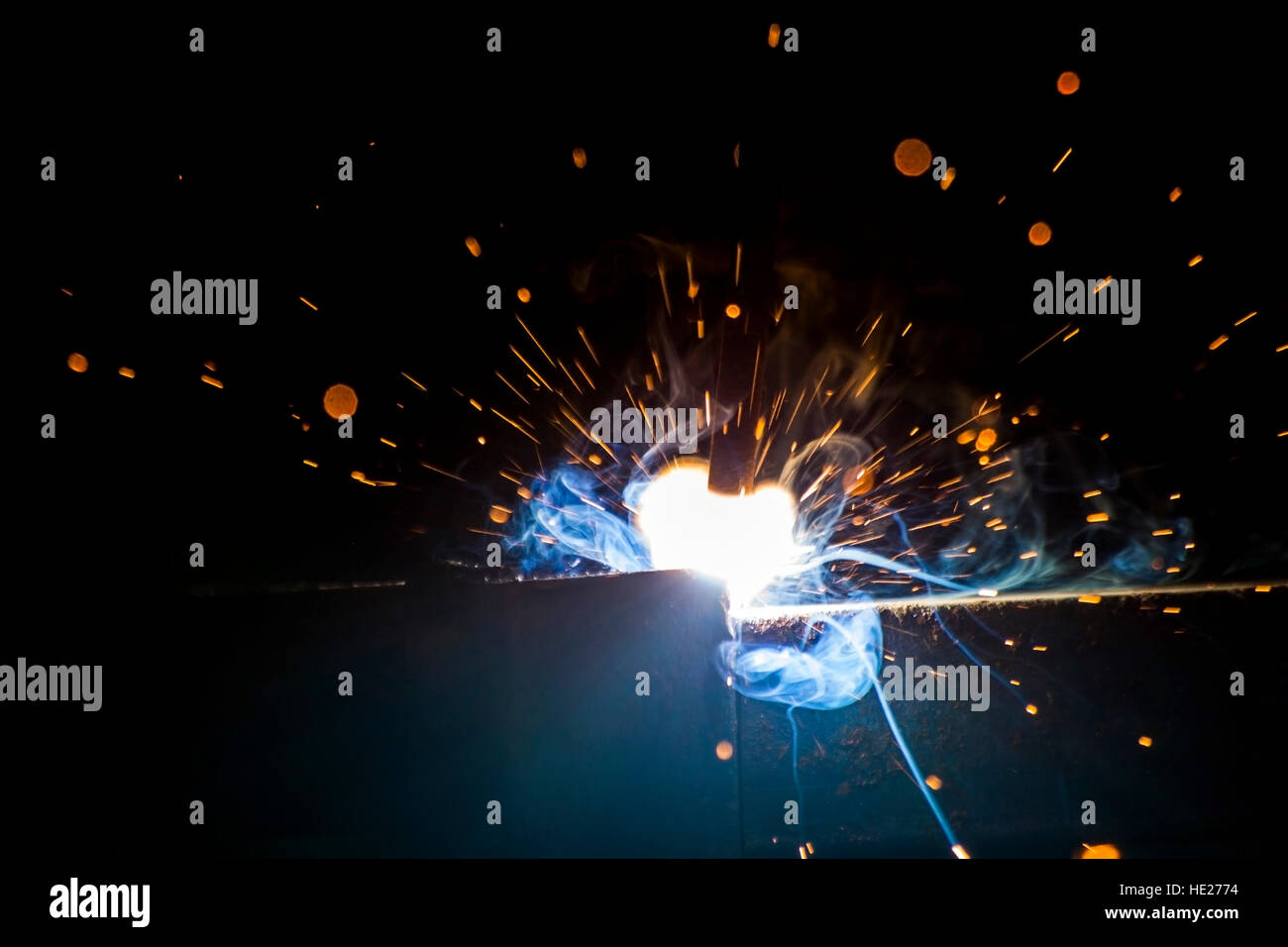 Worker Welding Metal with sparks and smoke Stock Photo - Alamy