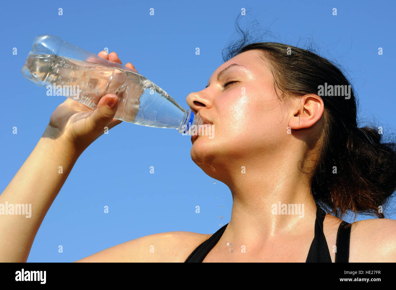 Thirst. Young woman drinks cold water in hot day Stock Photo - Alamy