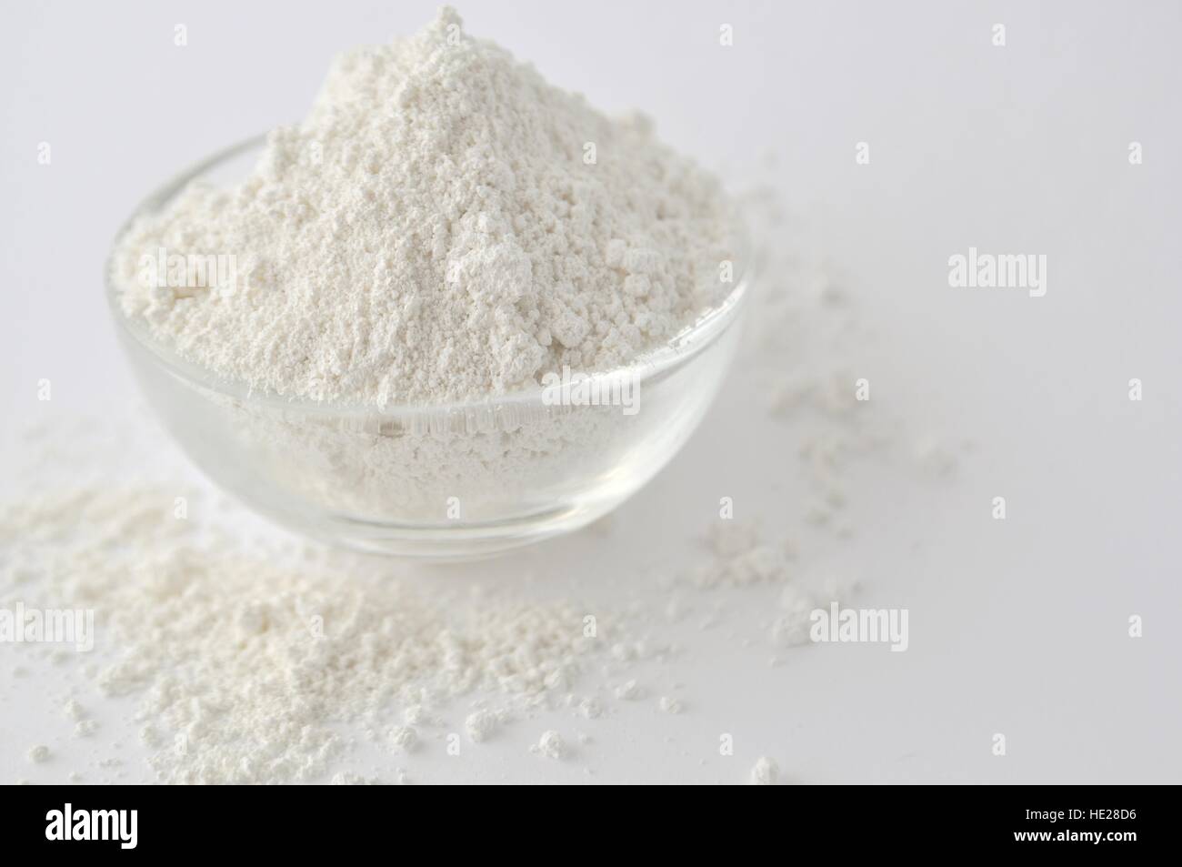 Kaolin powder in a glass bowl. Close up of a cosmetic mineral clay ...