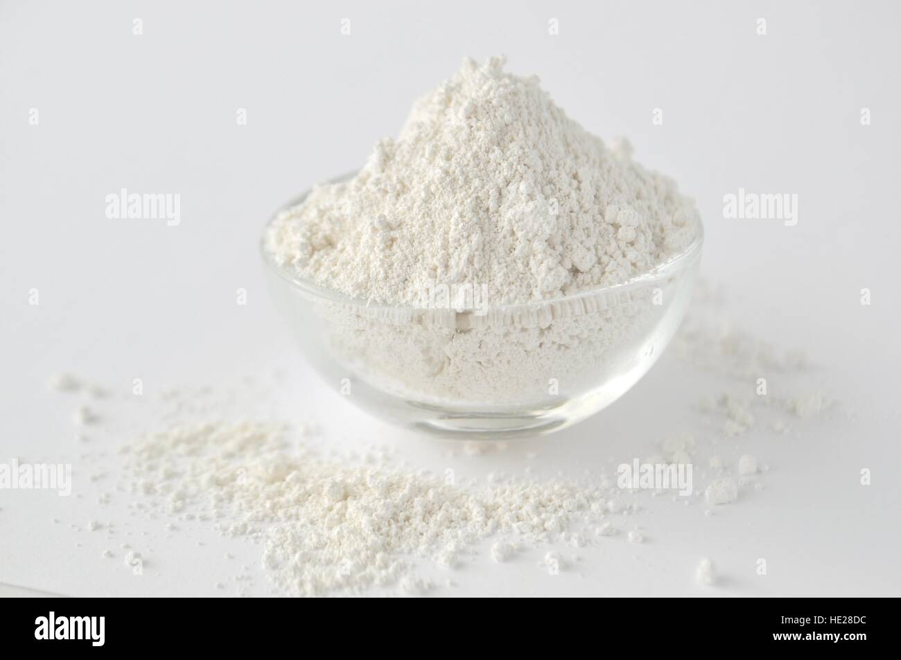 Kaolin powder in a glass bowl. Close up of a cosmetic mineral clay ...