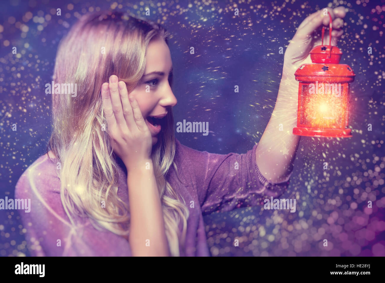 Portrait of a beautiful excited woman surprised looking on a glowing ...