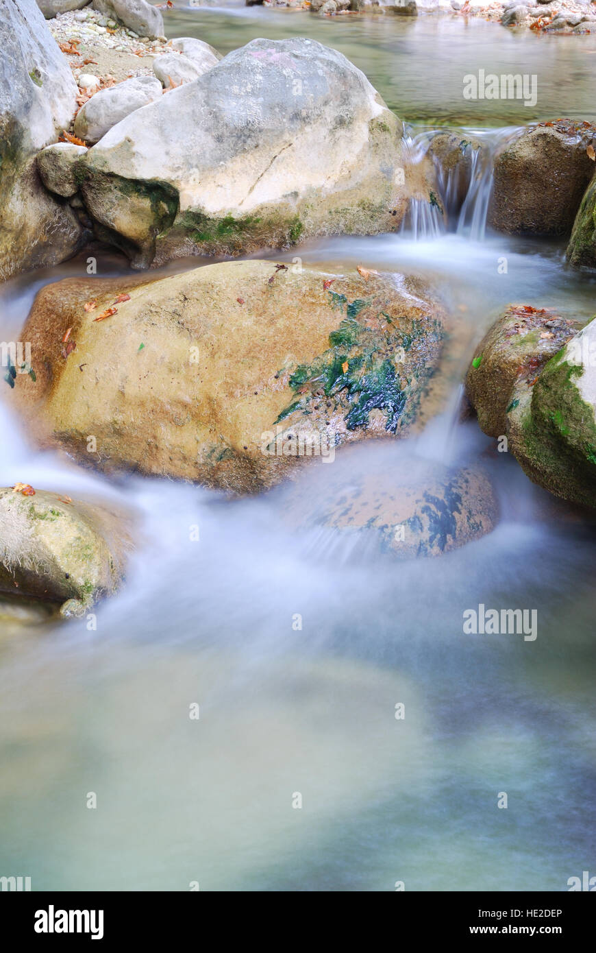 Clear water flowing over rocks into a small pool Stock Photo - Alamy