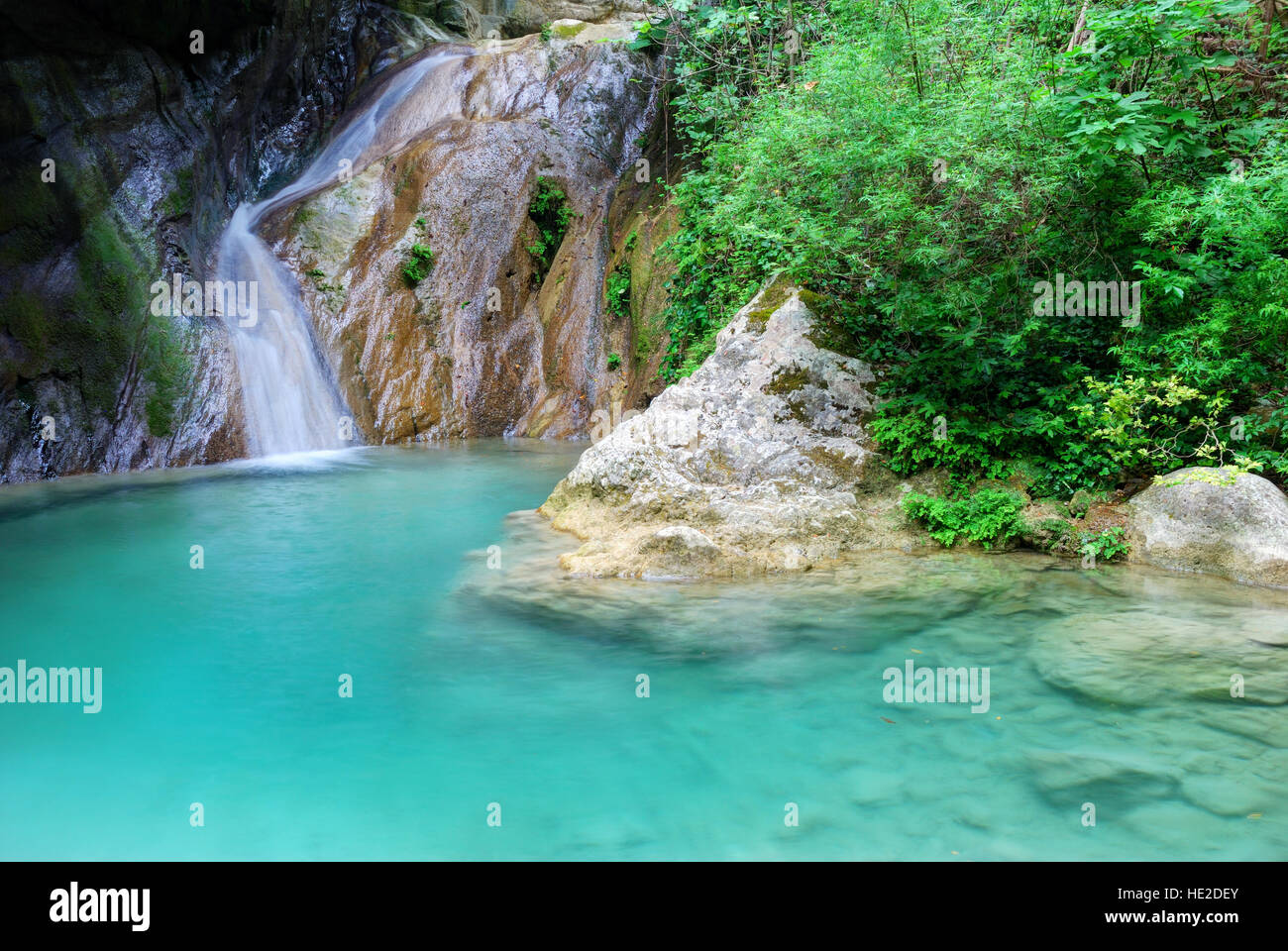 Natural pool with azure water and a small waterfall Stock Photo - Alamy