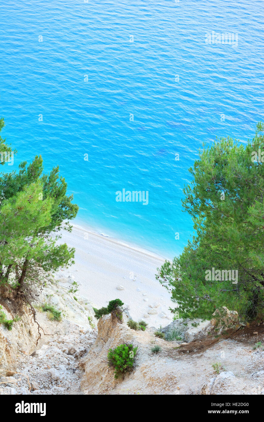 Beautiful beach under a high cliff with light blue sea Stock Photo - Alamy