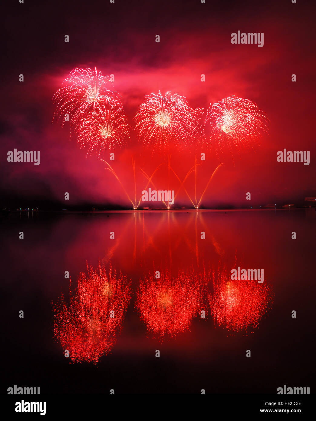 Beautiful red fireworks reflecting in water Stock Photo - Alamy
