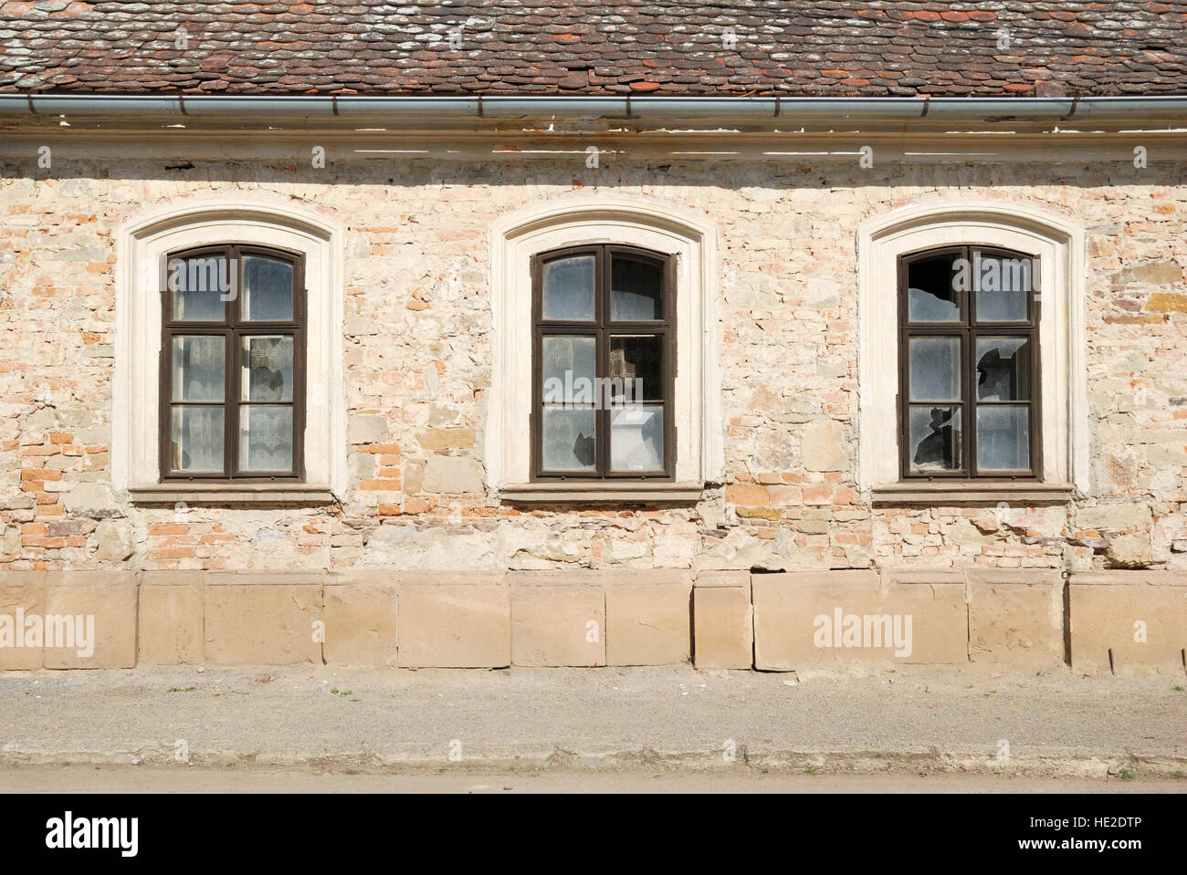 Three broken windows in a wall of a damaged house Stock Photo - Alamy