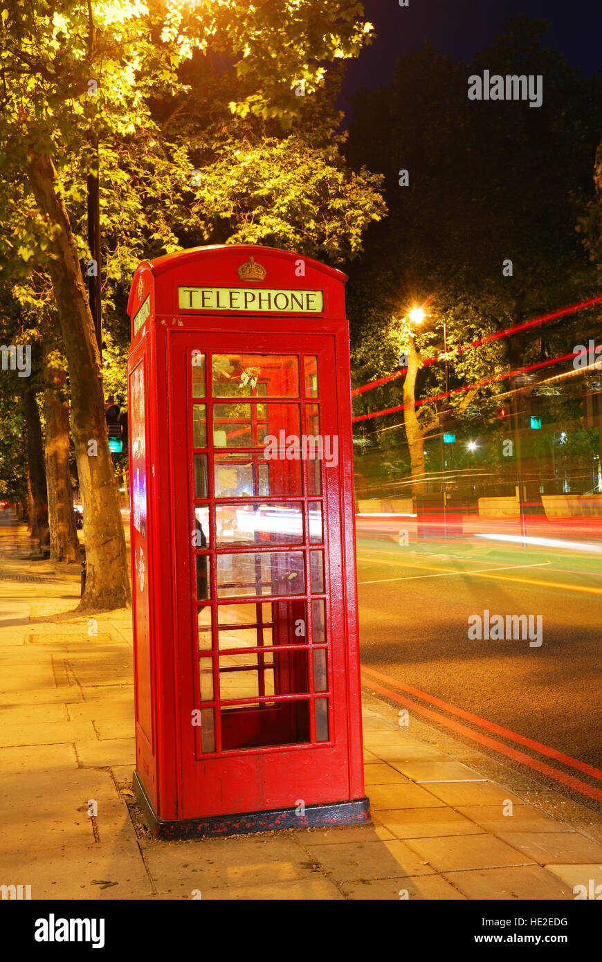 English telephone booth in the night with long exposure traffic lights ...
