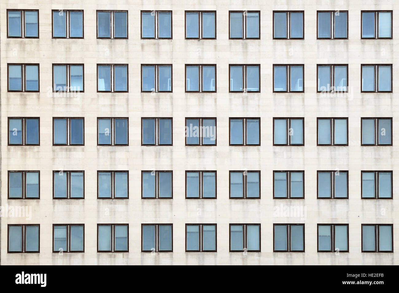 Multiple closed windows on a large office building Stock Photo - Alamy