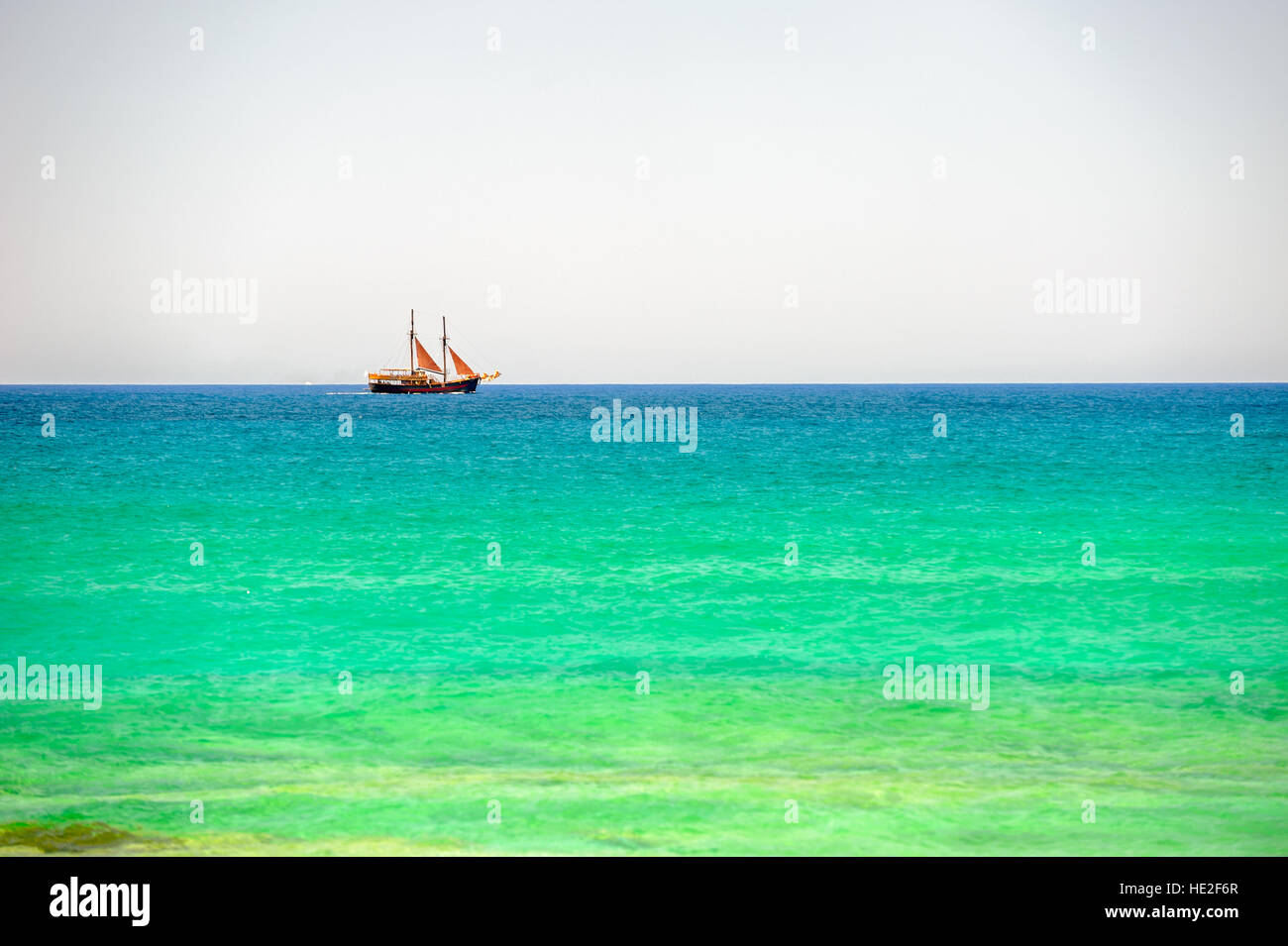 Sailing ship on horizon of azure sea Stock Photo - Alamy