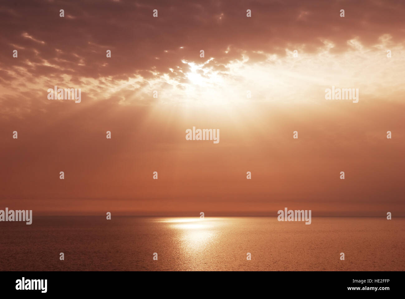 Sunset rays and clouds over evening sea Stock Photo - Alamy