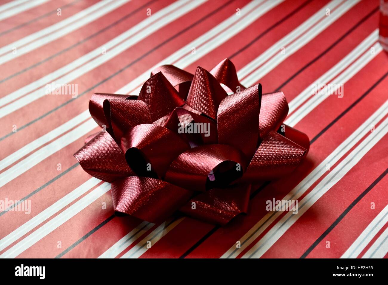 A Wrapped Christmas present with a red bow on top Stock Photo - Alamy