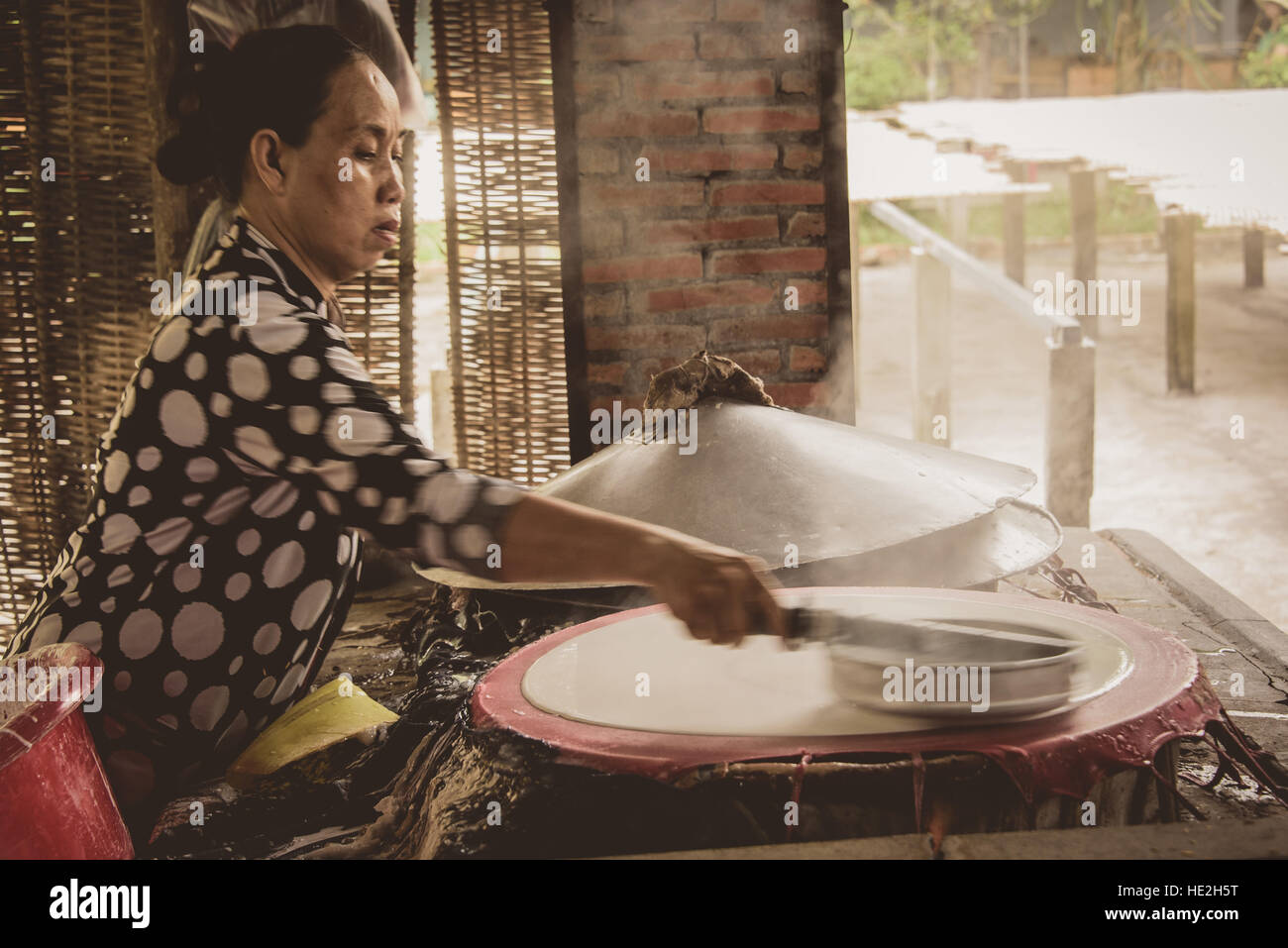 Vietnamese lady spreading rice paper disc onto as team bed for ...