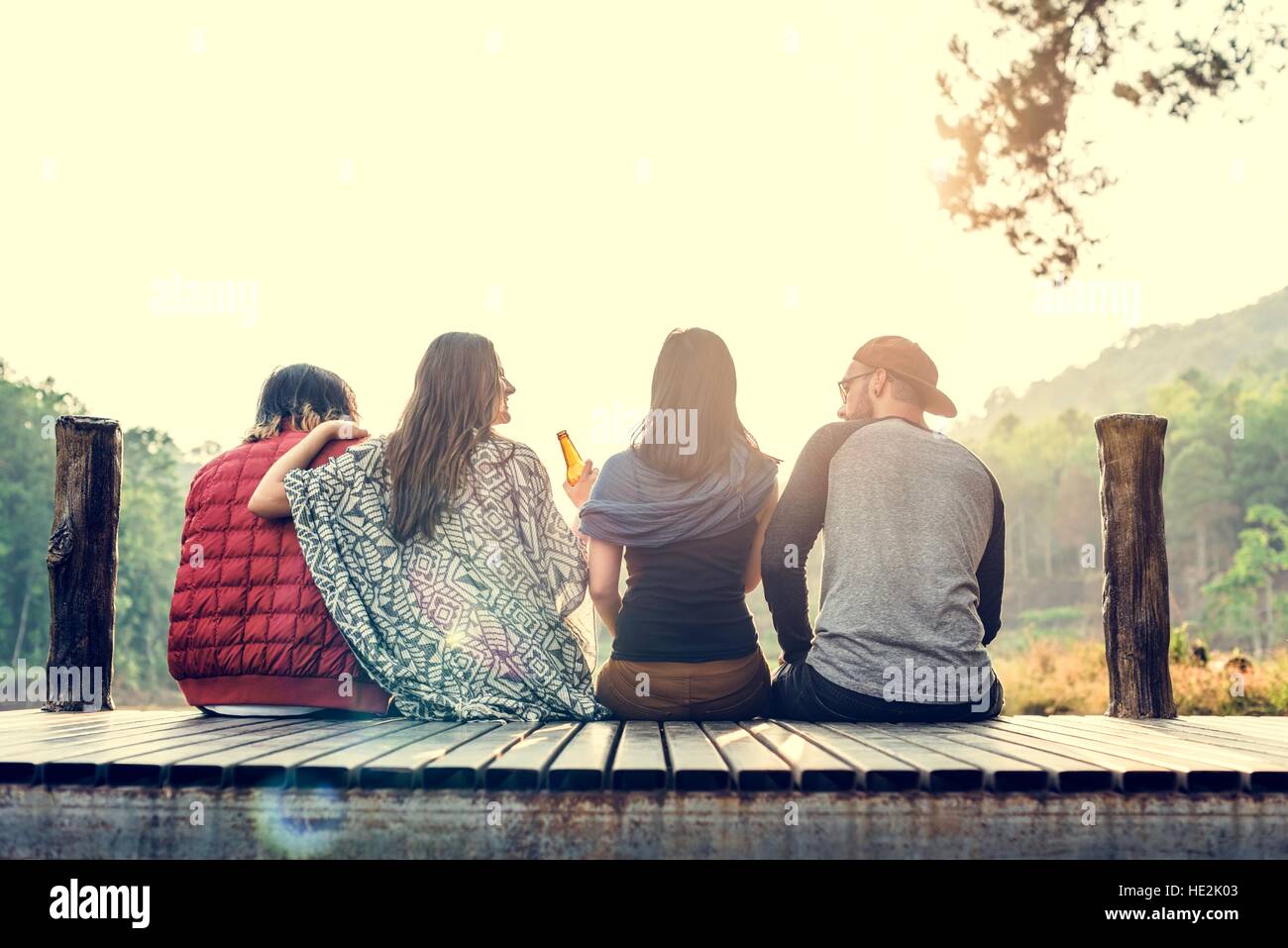 Friends Sitting in a Row Outdoors Concept Stock Photo - Alamy