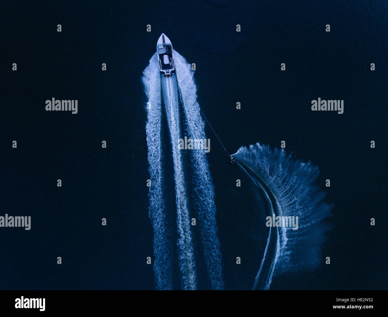 Aerial view of man wakeboarding on lake. Water skiing on lake behind a ...
