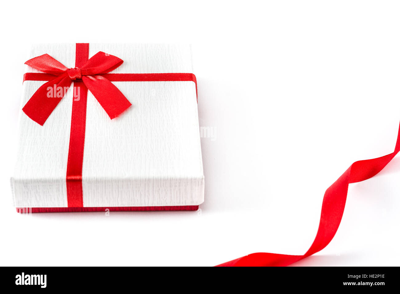 White gift box and red ribbon on white background Stock Photo - Alamy