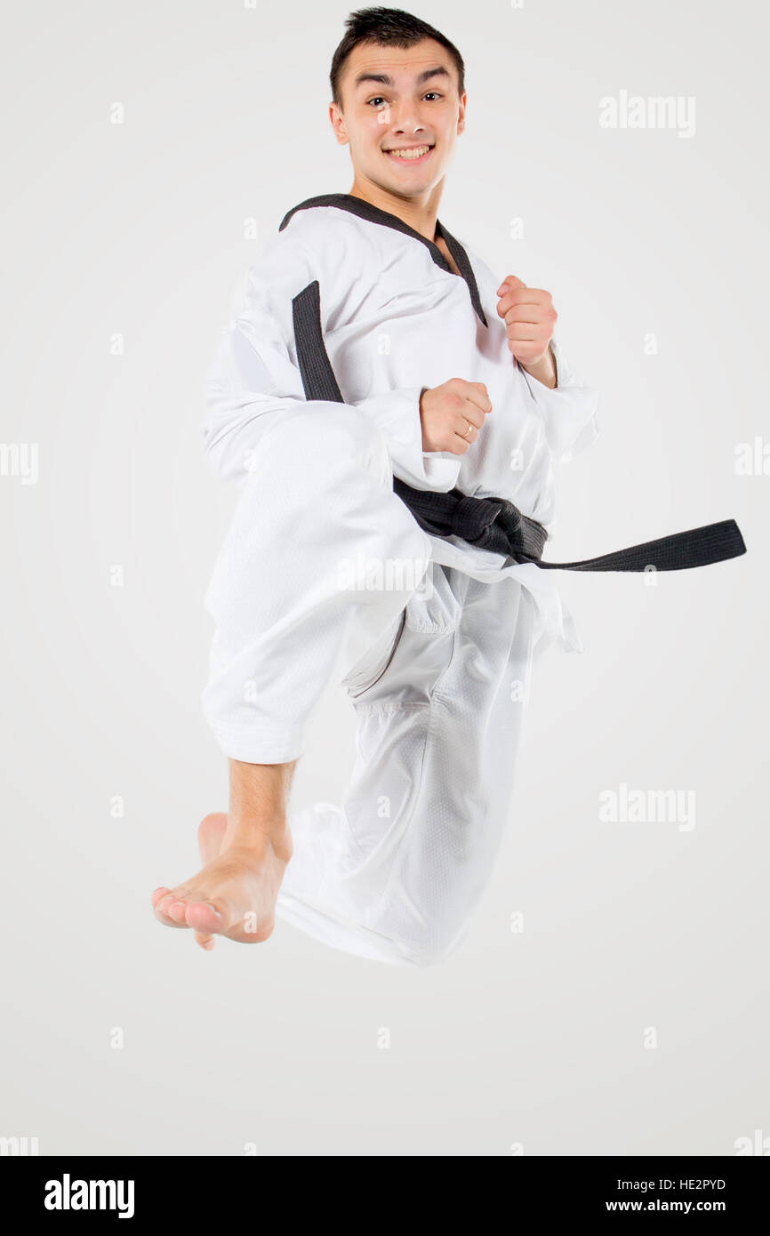 The karate man in white kimono and black belt training karate over gray background Stock Photo ...