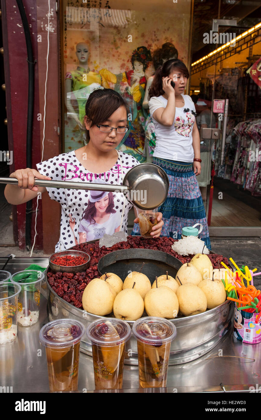Hui uyghur woman preparing food in Muslim quarter market Xian, China ...