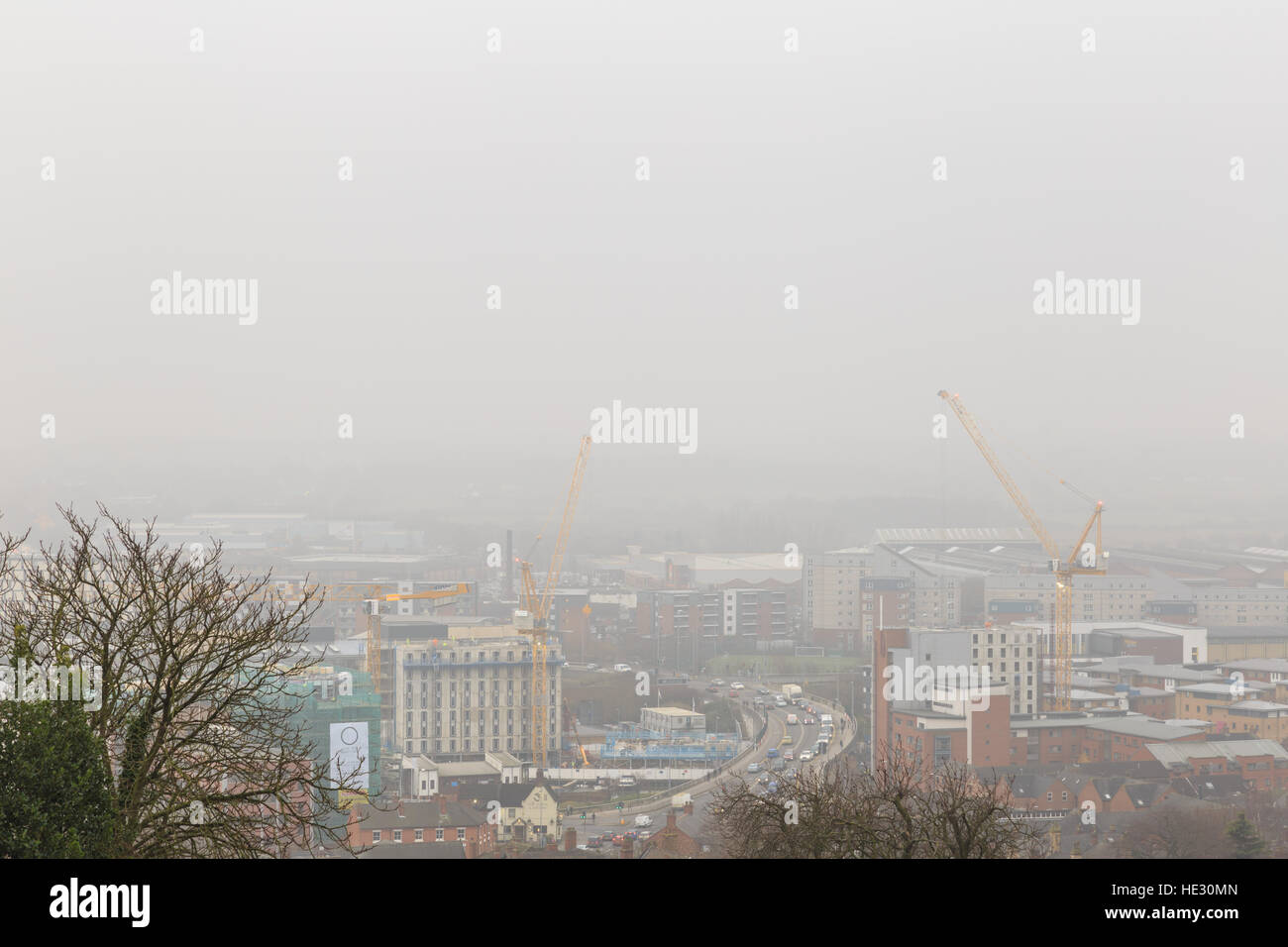 Construction cranes in fog on large commercial development project. In ...