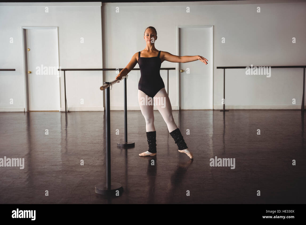 Ballerina practicing ballet moves at barre in ballet studio Stock Photo ...