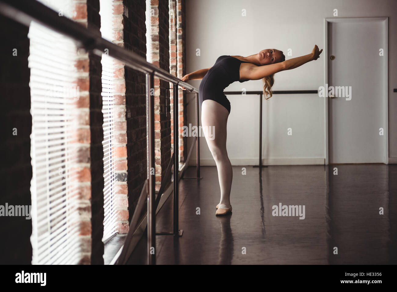 Ballerina practicing ballet dance at barre in ballet studio Stock Photo ...
