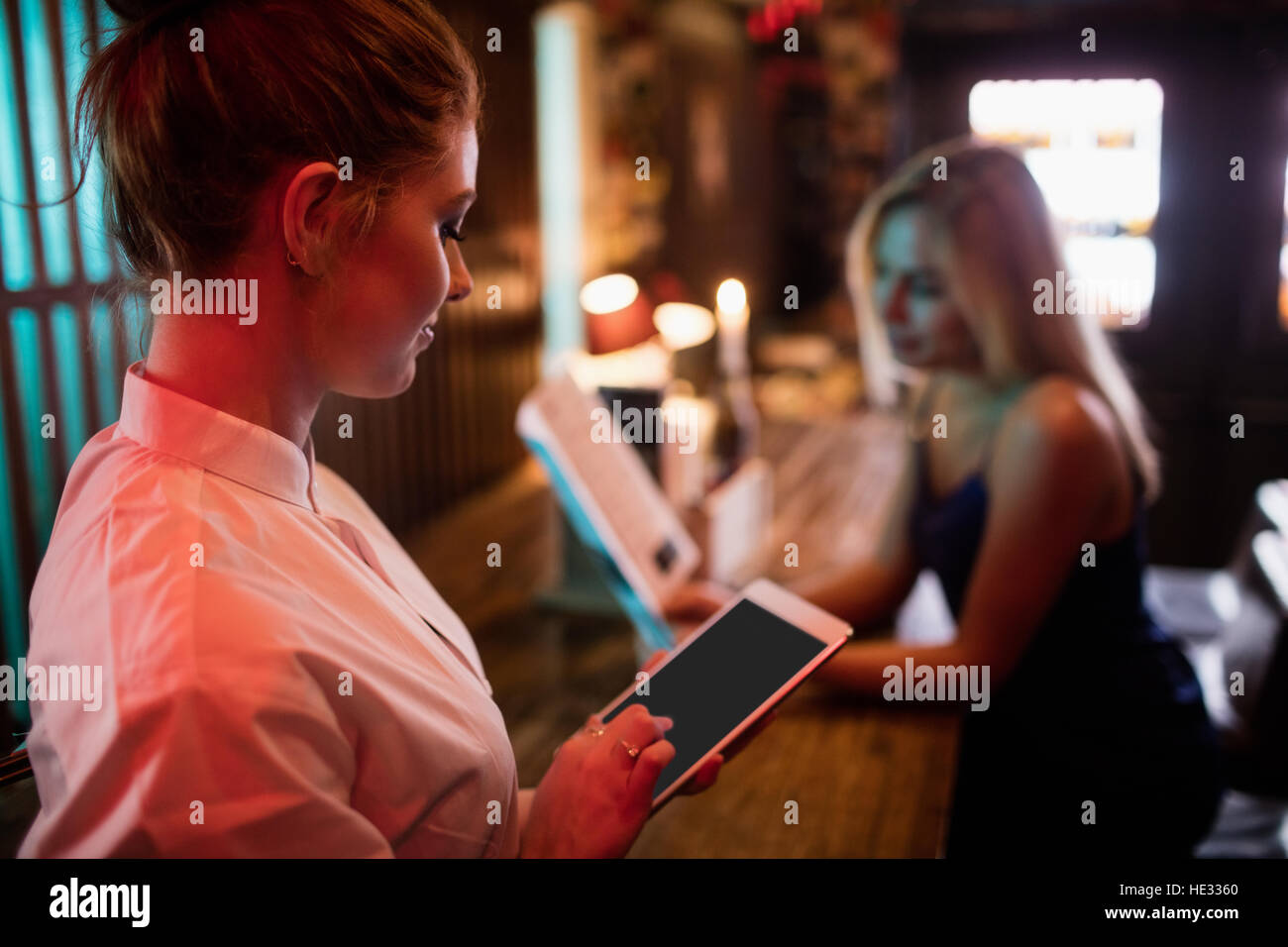 Waitress using digital tablet in the bar Stock Photo - Alamy