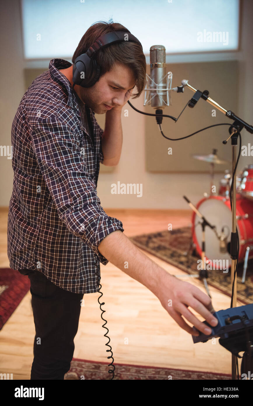 Man adjusting volume while singing in music studio Stock Photo - Alamy