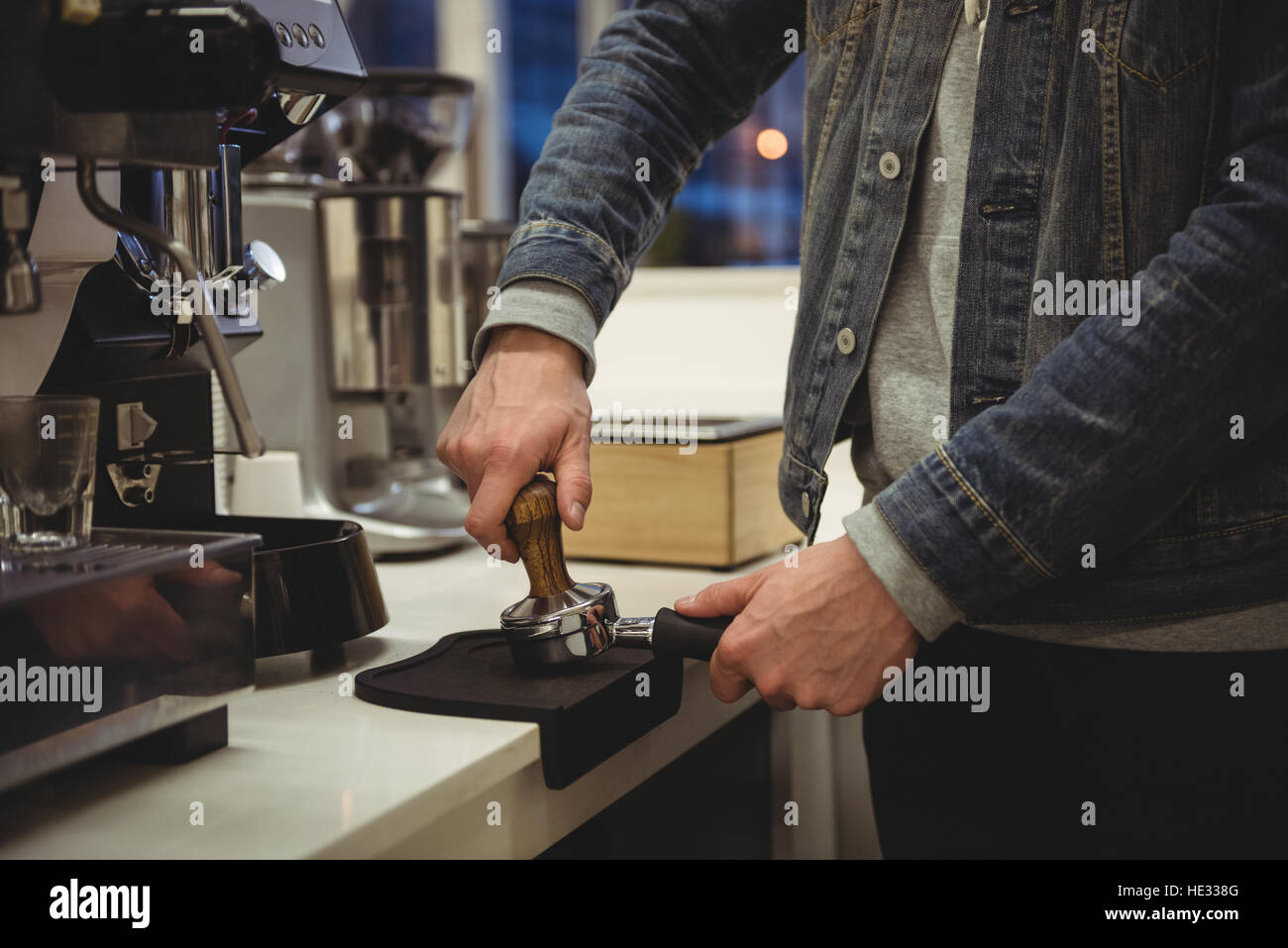Man pressing coffee with tamper in portafilter in coffee shop Stock ...