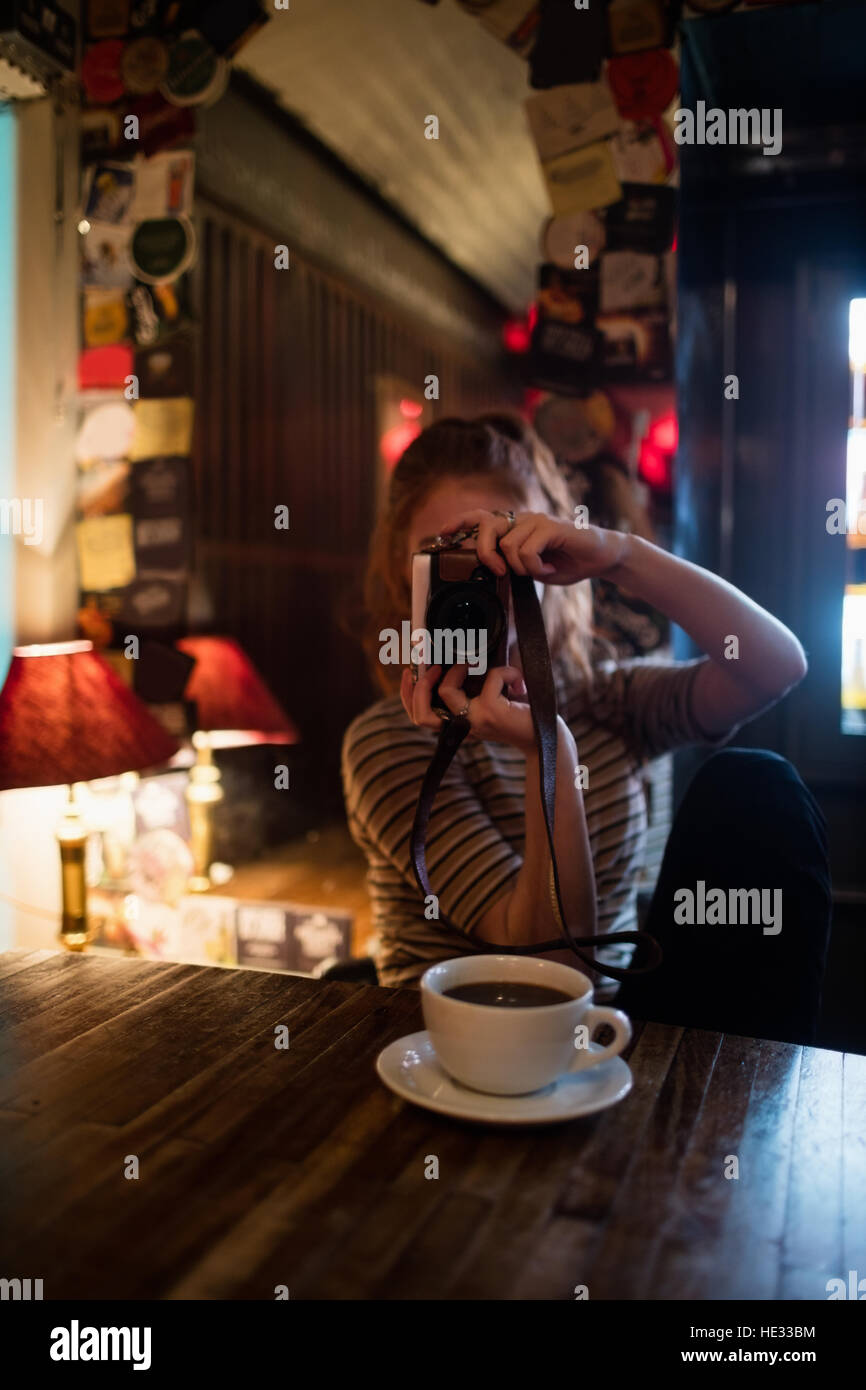 Woman clicking a picture with camera in the bar Stock Photo - Alamy