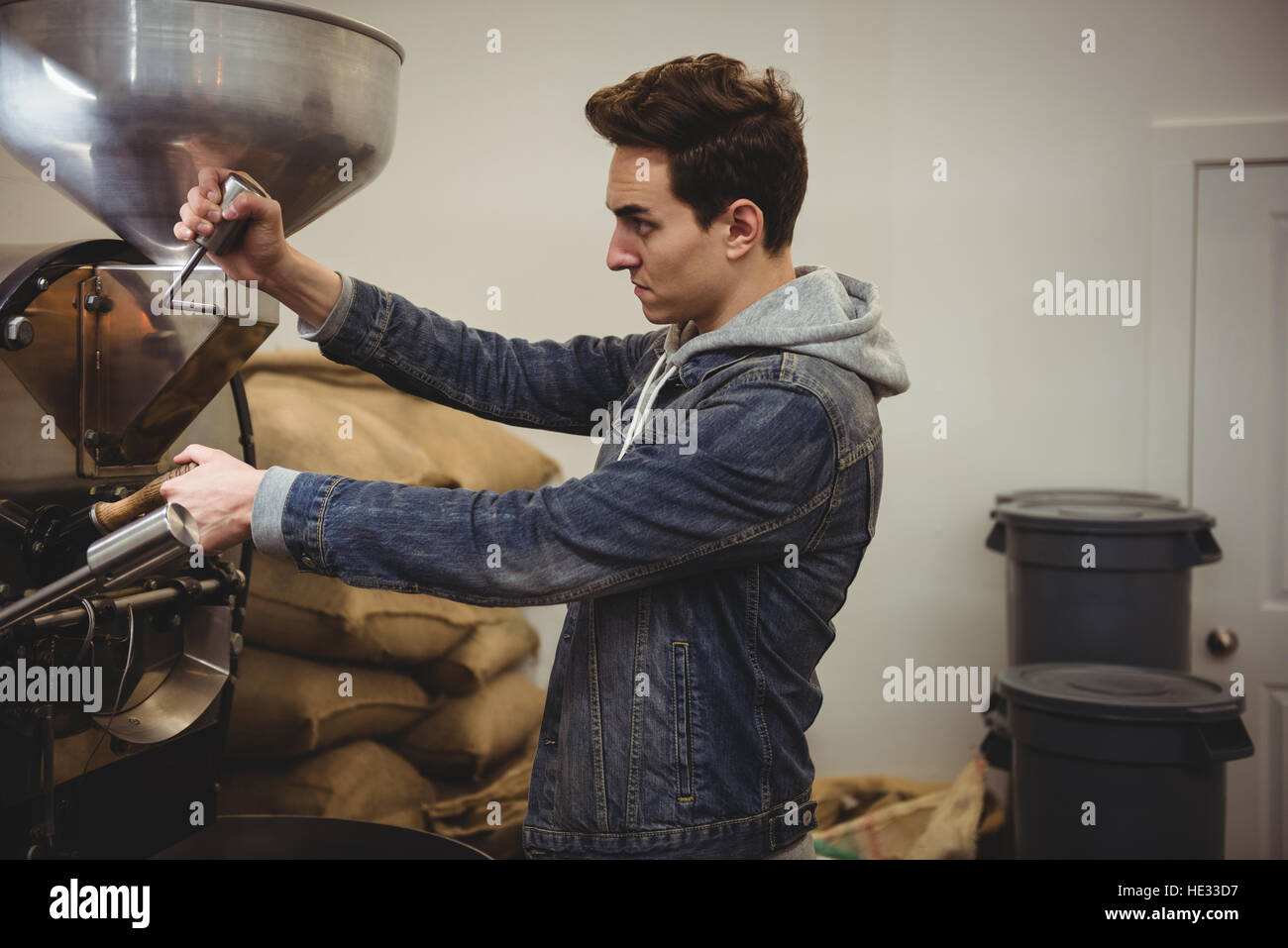 Man using coffee grinding machine in coffee shop Stock Photo - Alamy