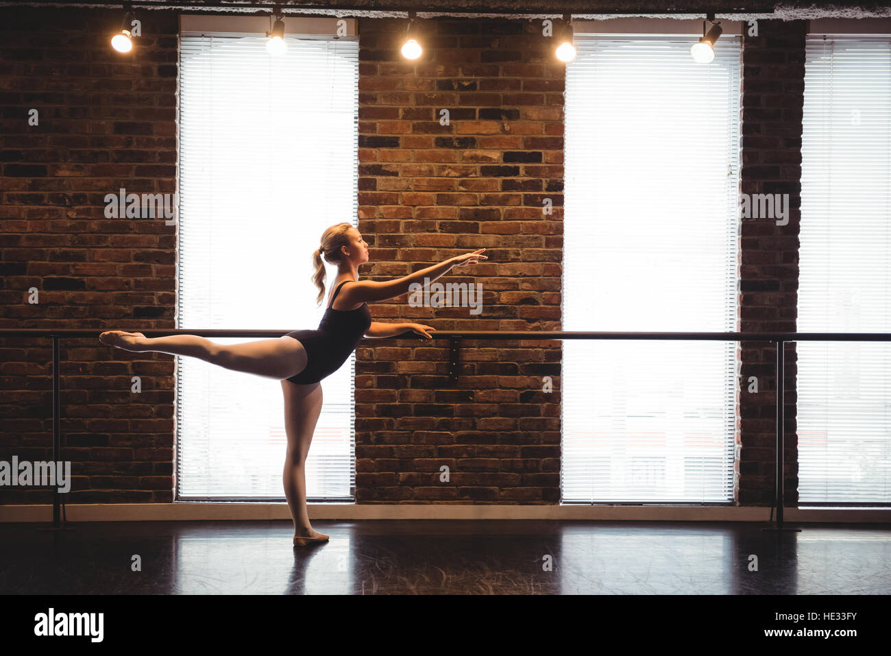 Ballerina practicing ballet dance at barre in ballet studio Stock Photo ...