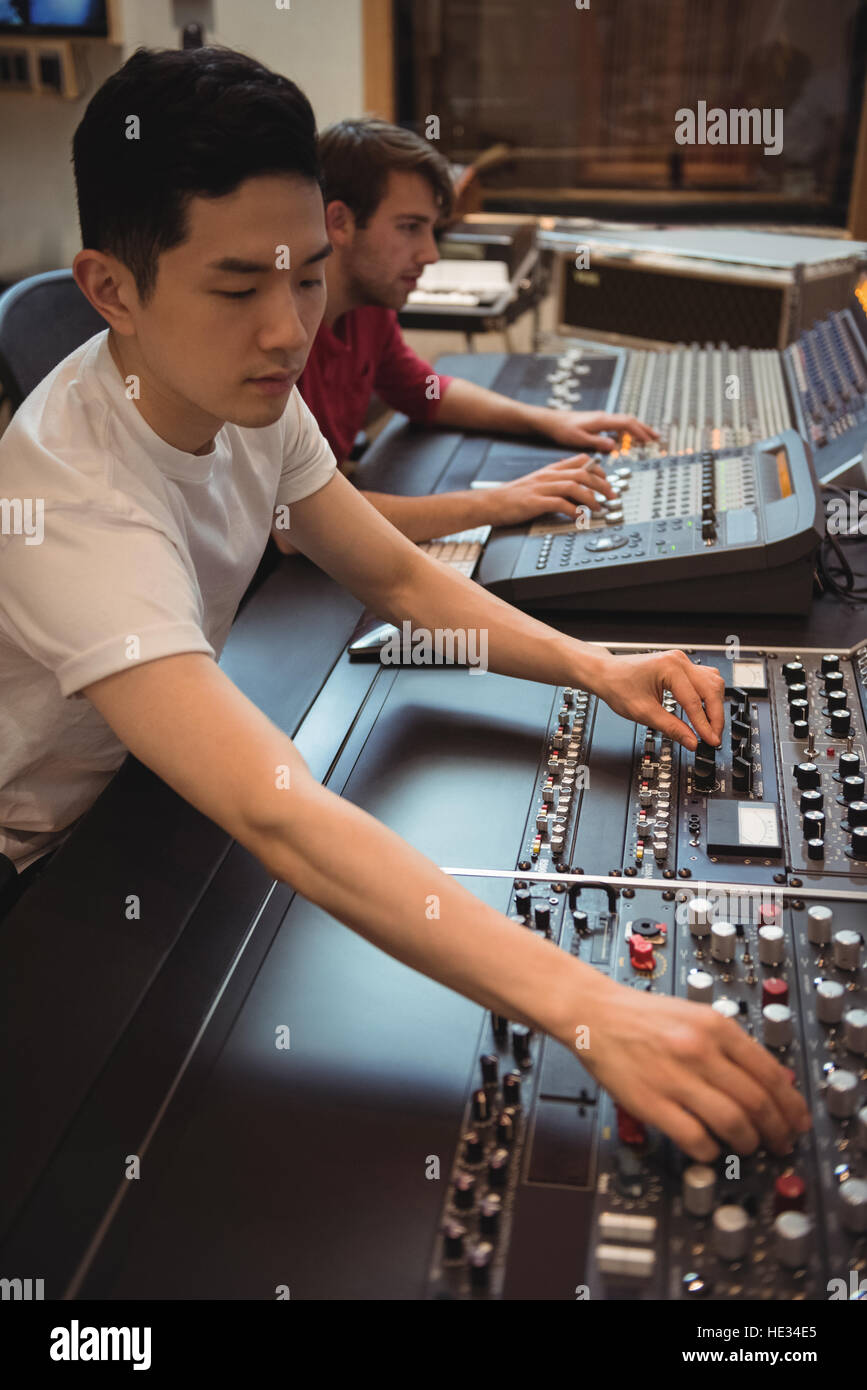 Audio engineers using sound mixer in recording studio Stock Photo - Alamy