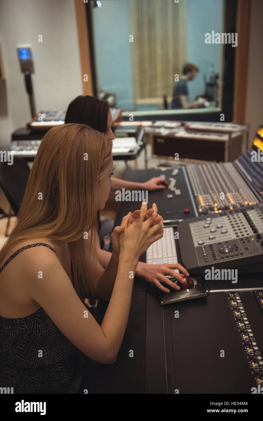 Audio engineer sitting with hands clasped near sound mixer in recording studio Stock Photo - Alamy