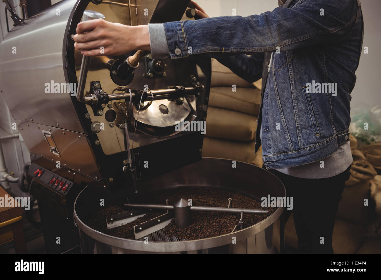 Man using coffee grinding machine in coffee shop Stock Photo - Alamy
