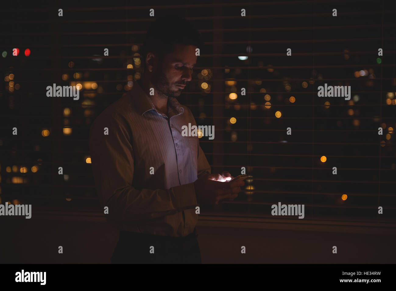Man smartphone standing window blinds hi-res stock photography and ...