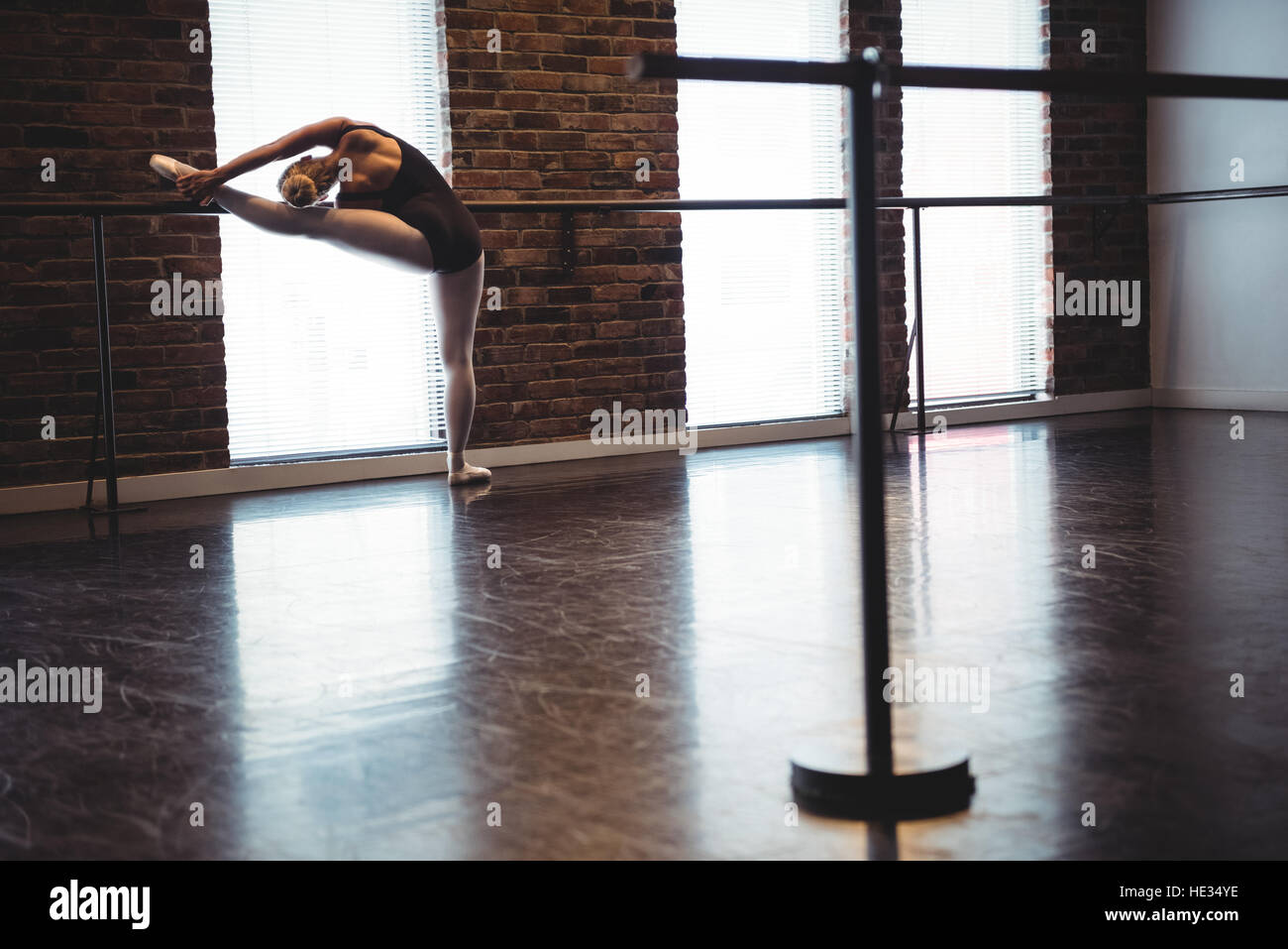 Ballerina stretching at barre in ballet studio Stock Photo - Alamy