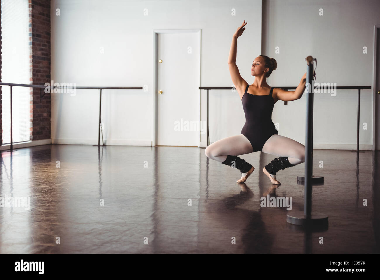 Ballerina practicing ballet moves at barre in ballet studio Stock Photo ...