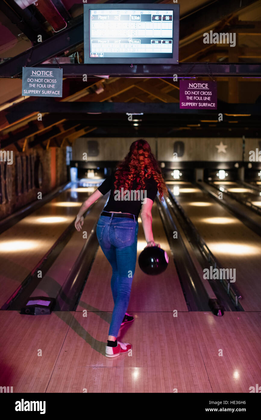 Rear view of woman playing bowling in bar Stock Photo - Alamy