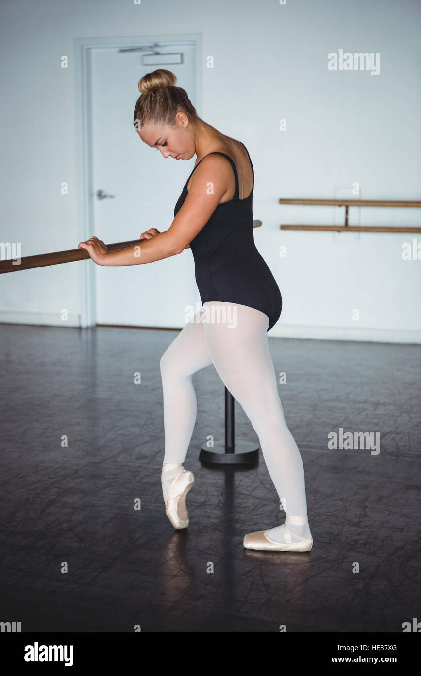 Ballerina practicing pointe at barre in ballet studio Stock Photo - Alamy