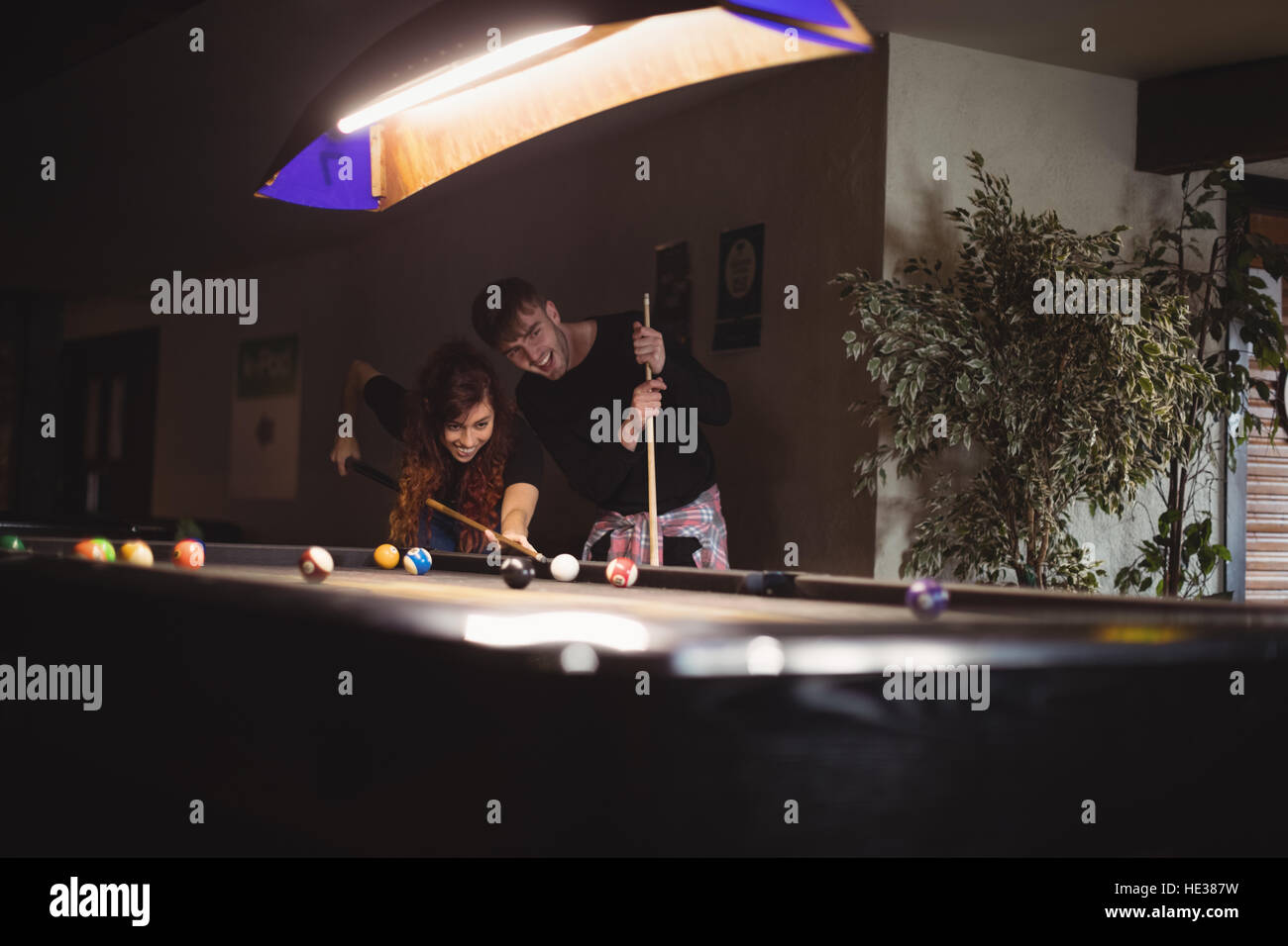 Young happy couple playing pool in bar Stock Photo - Alamy