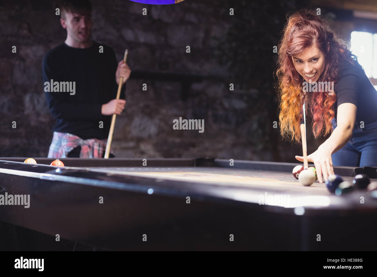 Young happy couple playing pool in bar Stock Photo - Alamy
