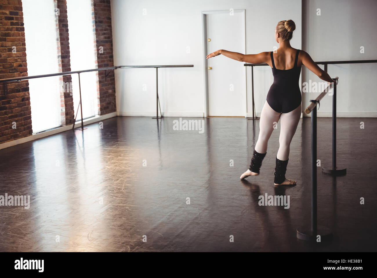 Ballerina practicing ballet moves at barre in ballet studio Stock Photo ...