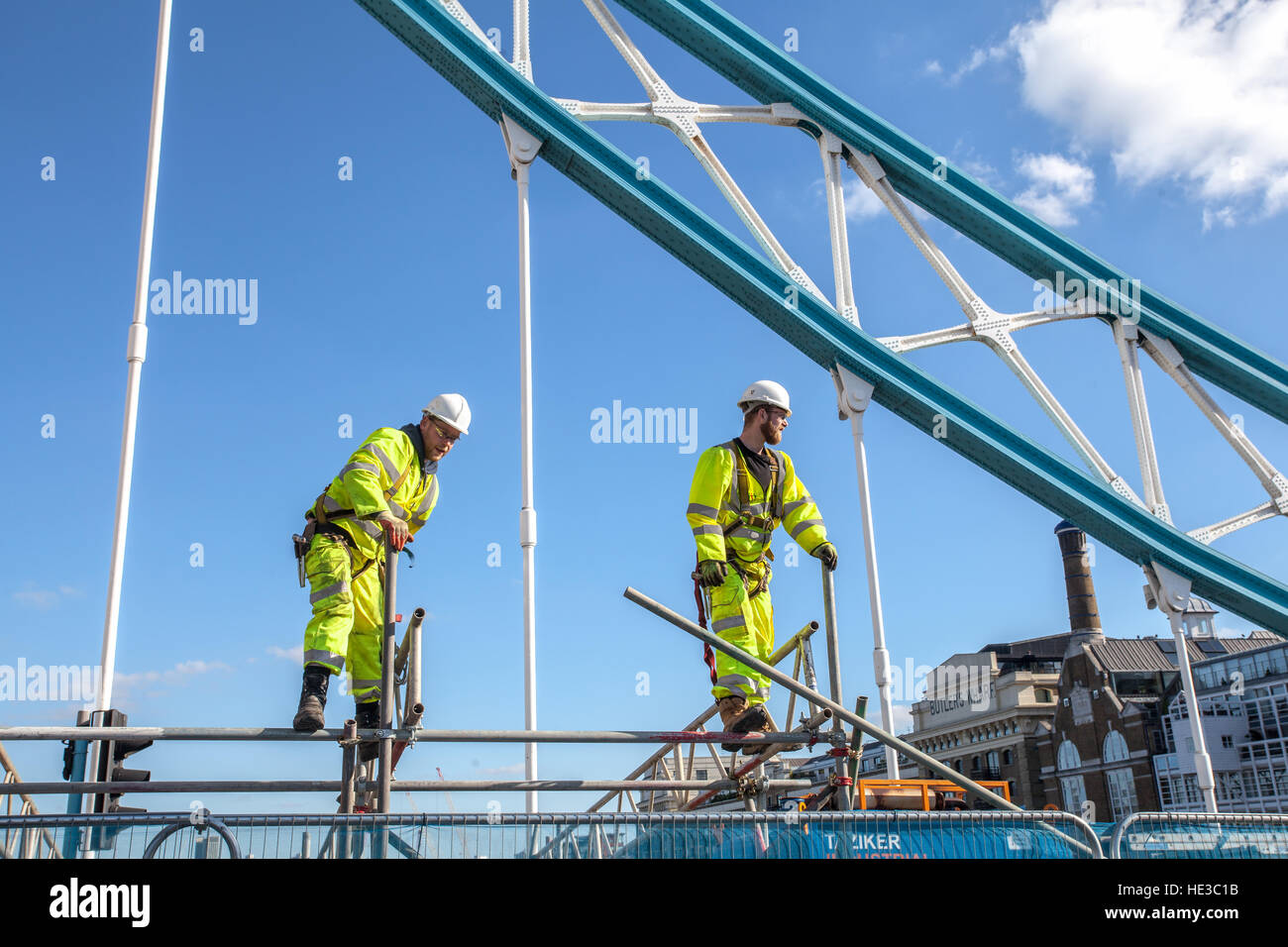 London UK, workers hanging on metal scaffolding on the Tower Bridge ...