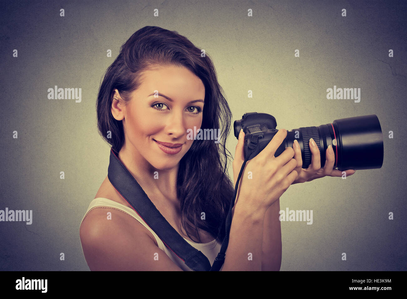 Professional female photographer holding digital camera and smiling ...
