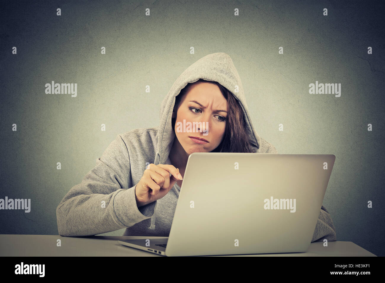 young stressed displeased worried woman sitting in front of laptop ...