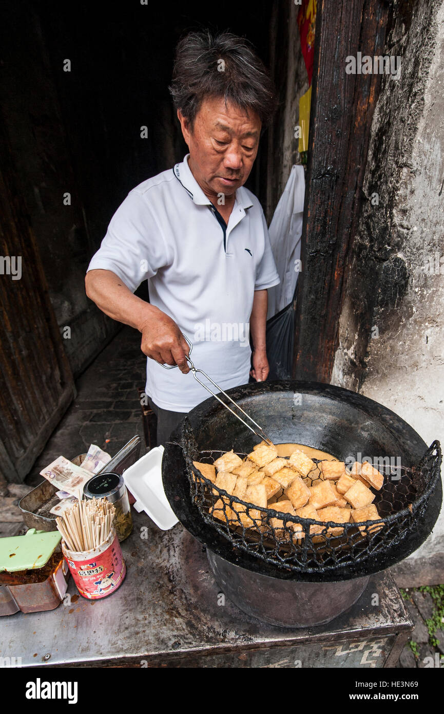 Man frying tiny spring rolls in the water village of Tongli, China ...