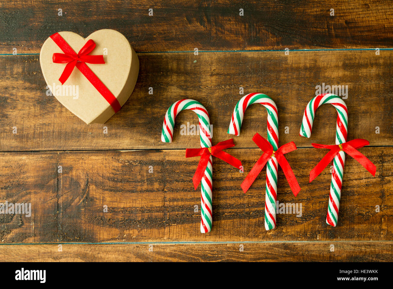 Present for Christmas and Candy Canes with ribbon on a wooden ...