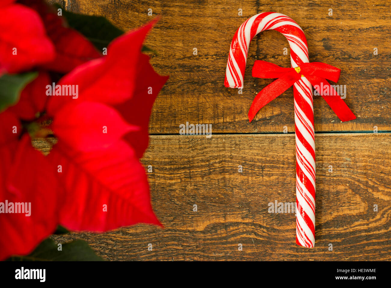 Candy cane with and plant with red leaves on a wooden background Stock ...